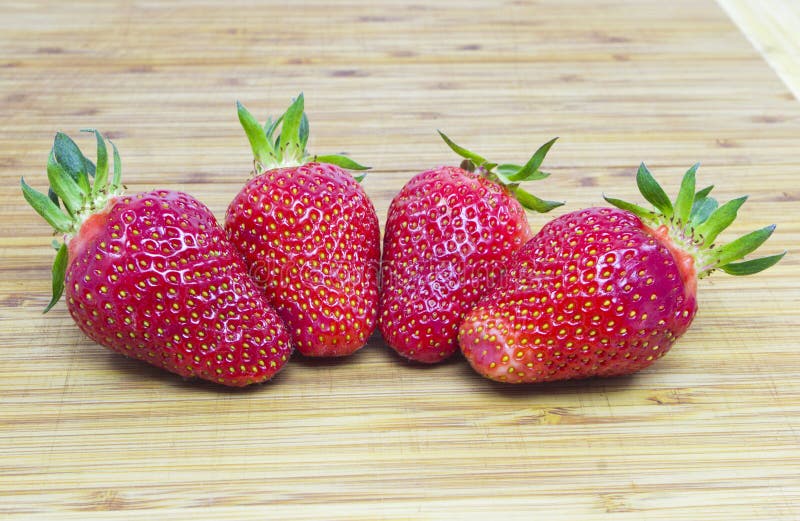 Four Strawberry Fruits with Green Leaves and Flowers Stock Photo ...