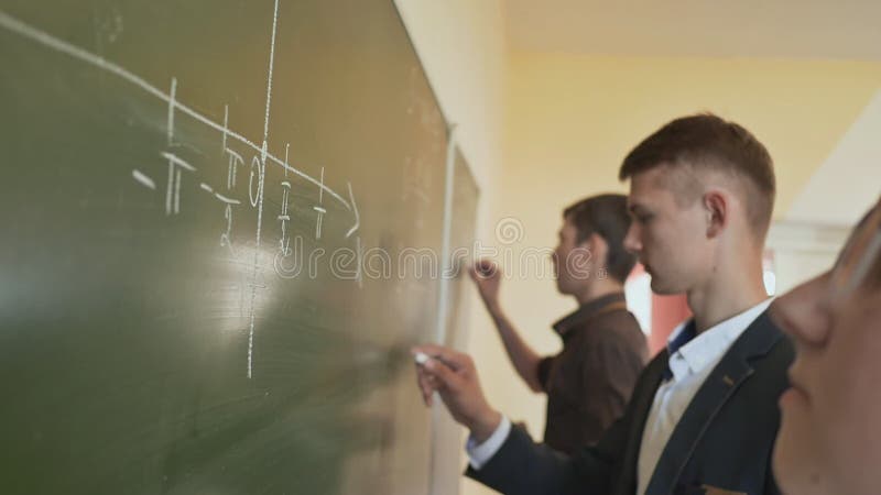 Four Students Write on the Blackboard Mathematical Formulas in the ...