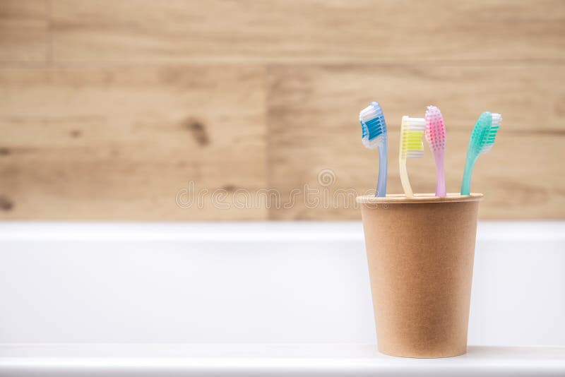 Four Toothbrushes in a Paper Cup in the Bathroom Stock Image - Image of ...
