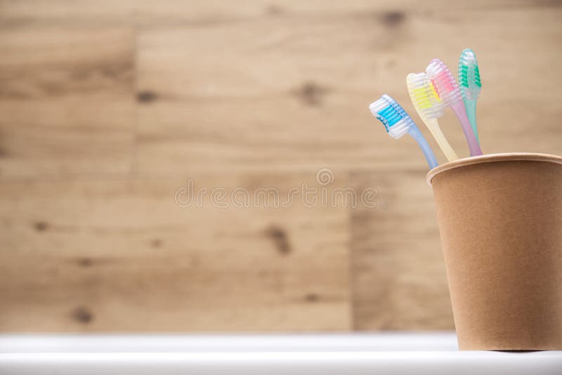 Four Toothbrushes in a Paper Cup in the Bathroom Stock Photo - Image of ...