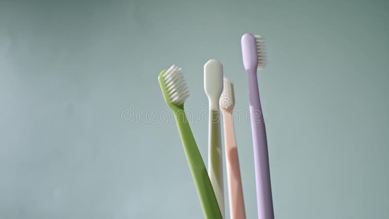 Four Toothbrushes Spin. Pastel Soft Colors of the New Toothbrushes are ...