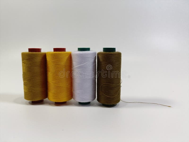 Four Vertical Sewing Thread Spools in Yellow, White, and Brown on White ...