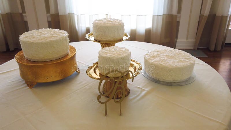Four Wedding Cakes Stand on a Round Table with a White Tablecloth Stock ...