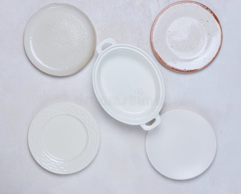 Four White Empty Ceramic Plates of Different Shapes and Baking Dish on ...