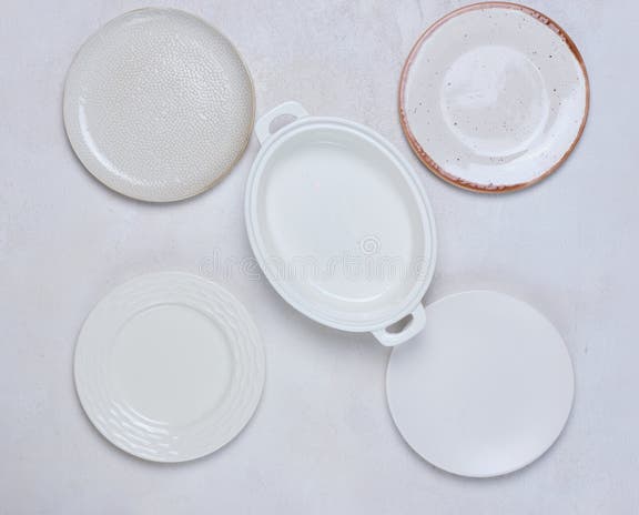 Four White Empty Ceramic Plates of Different Shapes and Baking Dish on ...