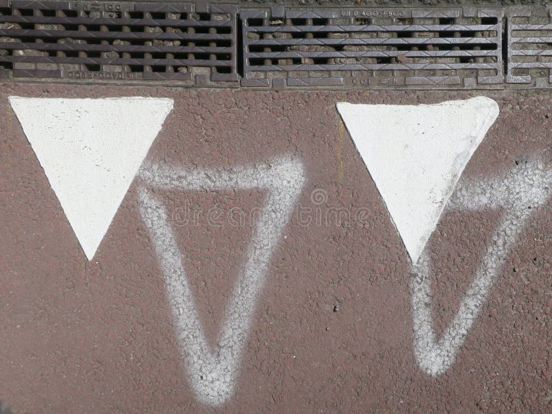 Four White Triangles Painted on a Bicycle Path Stock Photo - Image of ...