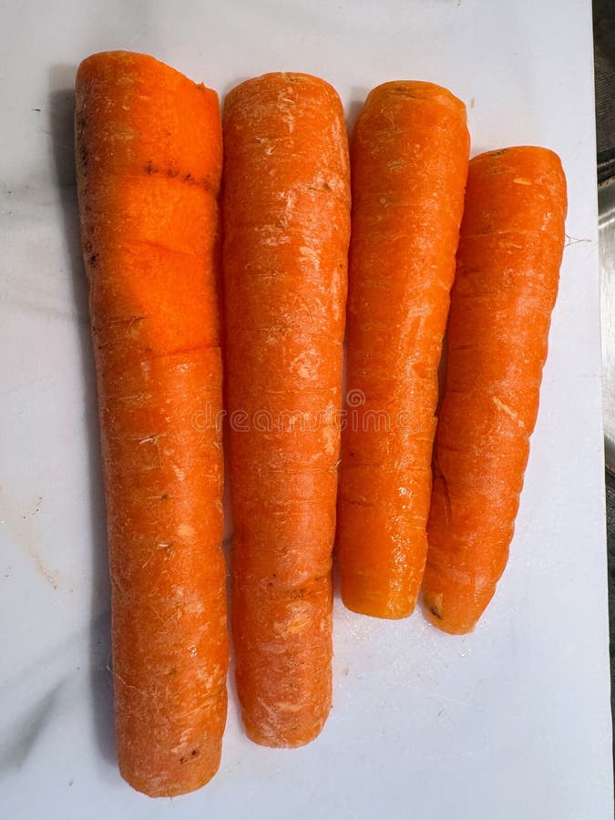 Four Whole Carrots on Nylon Chopping Board Stock Photo - Image of heap ...