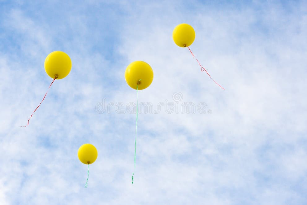 Four yellow baloons rising stock photo. Image of rubber - 5632558