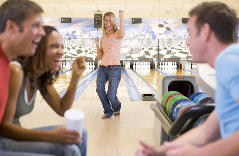 Four Young Adults Cheering in a Bowling Alley Stock Image - Image of ...