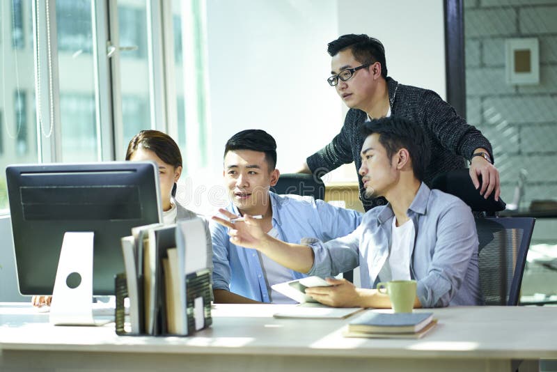Four Young Asian Entrepreneurs Discussing Business in Office Stock ...