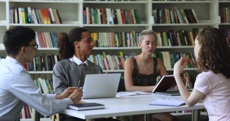 Four Multi Ethnic Students Engaged in Teamwork in Library Stock Footage ...