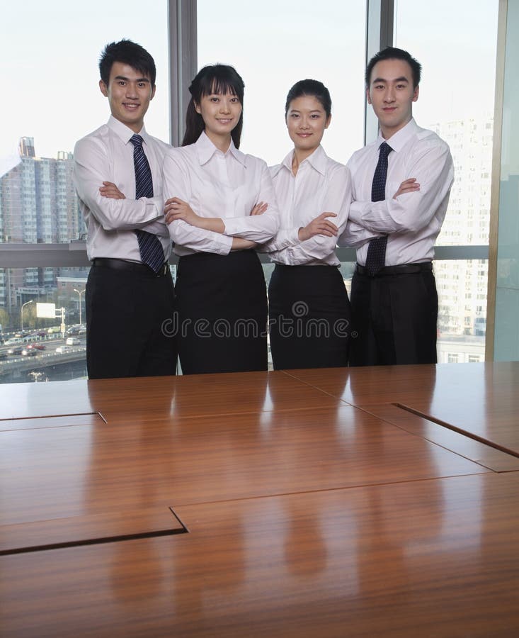 Four Young Business People Standing by Conference Table Stock Image ...