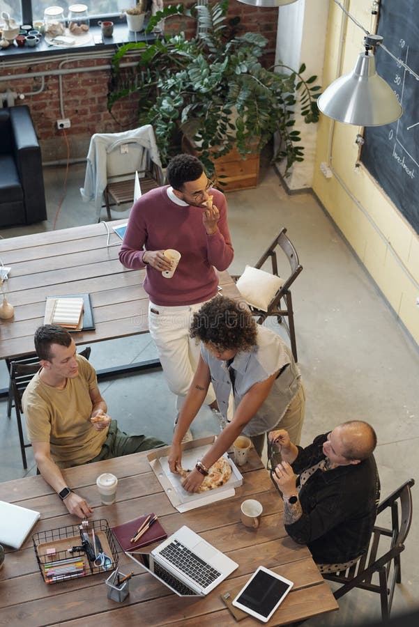 Four Young Co-workers Gathered by Table for Lunch Break Stock Image ...