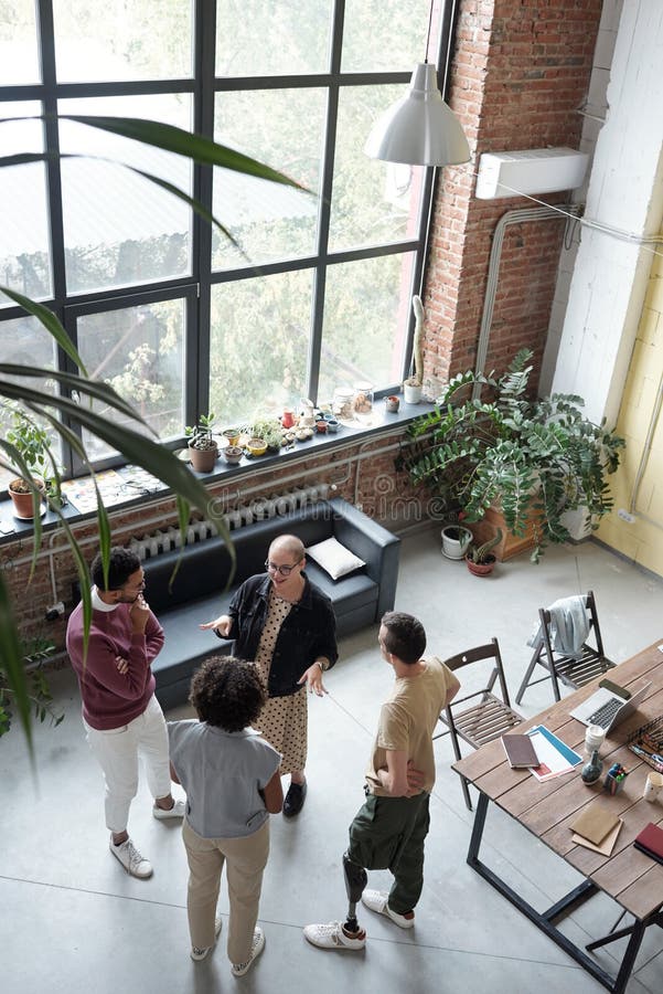 Four Young Contemporary Office Workers Standing by Table during ...