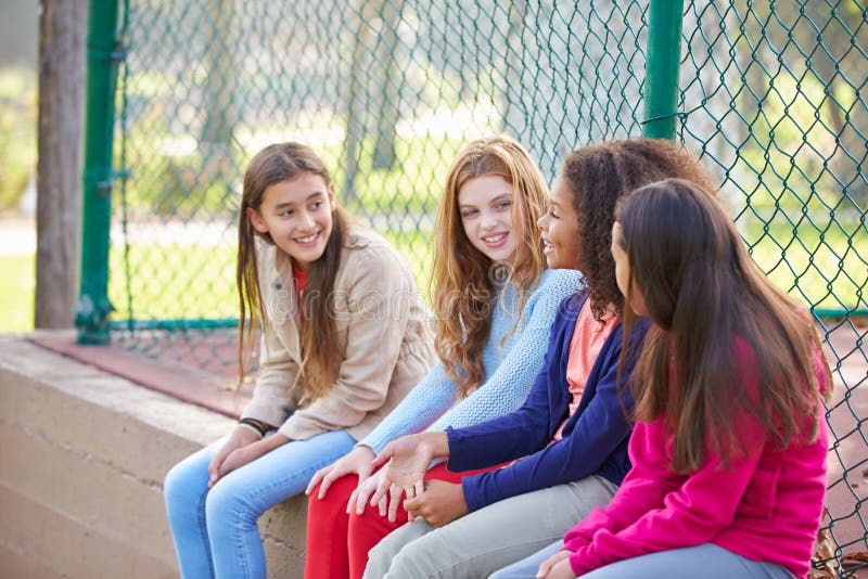 Four Young Girls Hanging Out Together in Park Stock Photo - Image of ...