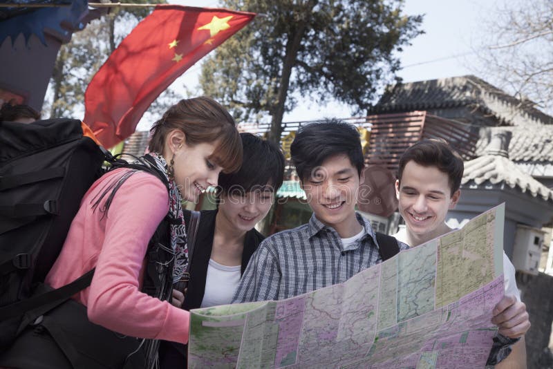 Four Young People Looking at Map. Stock Image - Image of direction ...
