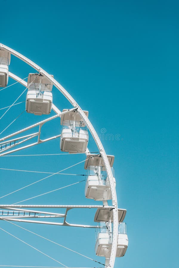 White Ferris Wheel with Glass Light Blue Cabins Against Blue Sky, Dubai ...