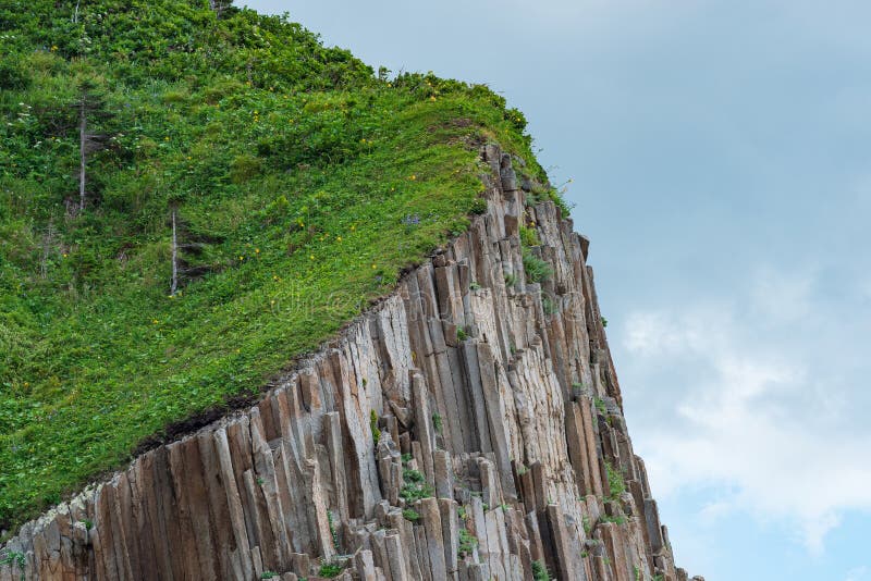 Fragment of a Cliff Made of Columnar Basalt with Lush Grass on Top ...