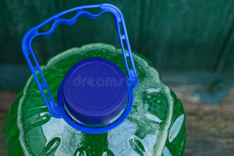 Part of a Bottle with a Liquid with a Blue Stopper and Handle Stock ...