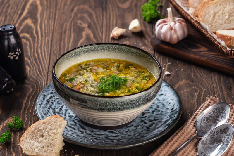 Fragrant Chicken Soup with Egg with Garlic and Herbs on a Wooden Table ...