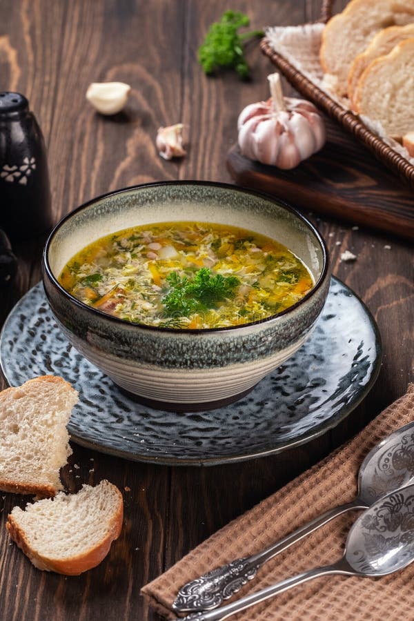 Fragrant Chicken Soup with Egg with Garlic and Herbs on a Wooden Table ...