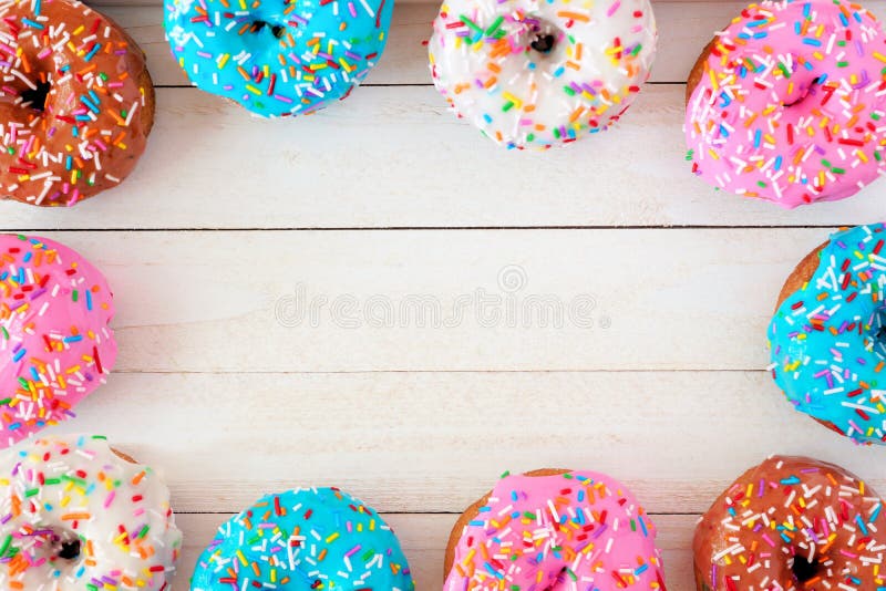 Frame Of Assorted Donuts With Pastel Icing Against White Wood Stock ...