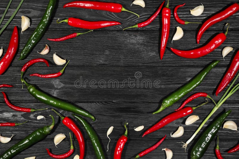 Frame of Different Chili Peppers and Garlic on Black Wooden Table, Flat ...