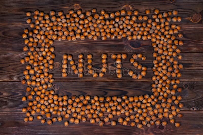 Frame of Hazelnuts with Shells on Brown Wooden Boards. the Word Nuts is ...