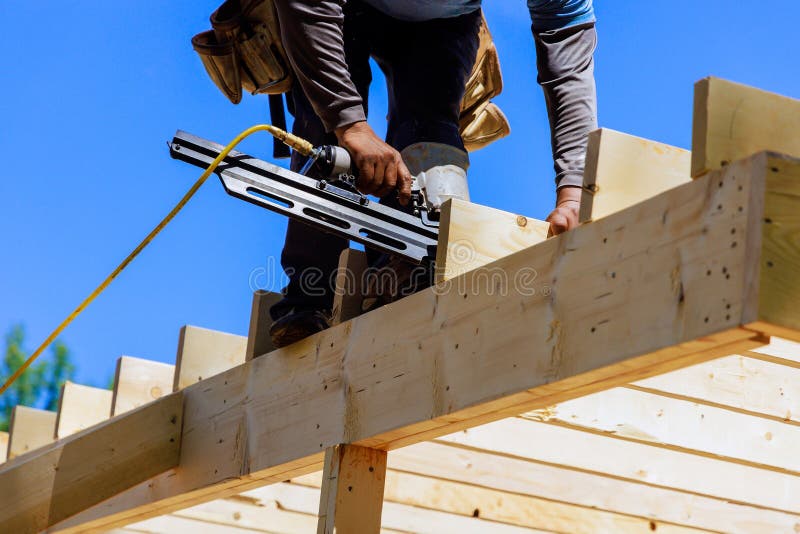 Framer Worker Installing Beams Using Air Nails Hammer in a Nailing ...