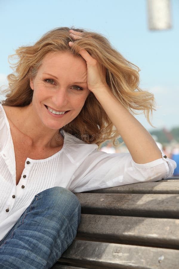 Frau gesessen auf Bank stockbild. Bild von feiertage - 26504977