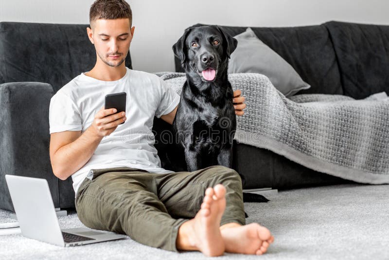 Freelancer Guy Sitting at Home Working with a Dog in an Embrace, Black ...