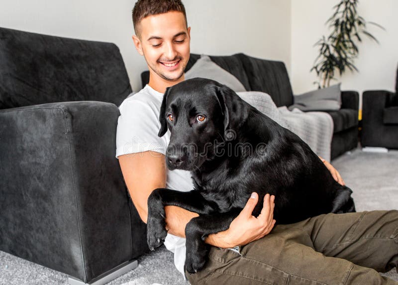 Freelancer Guy Sitting at Home Working with a Dog in an Embrace, Black ...