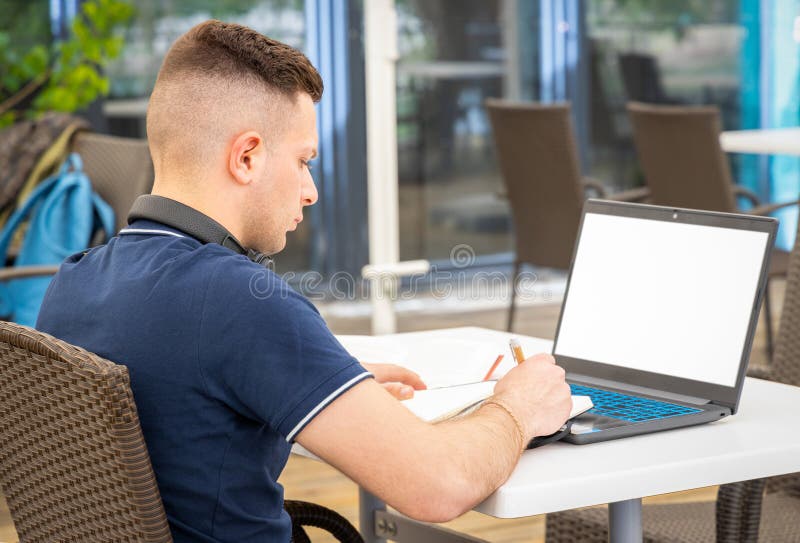 Freelancer Sitting at a Table and Working at a Laptop with a Mock-up ...