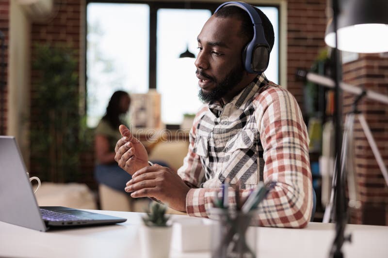 Freelancer with Wireless Headphones Talking and Explaining while Doing ...