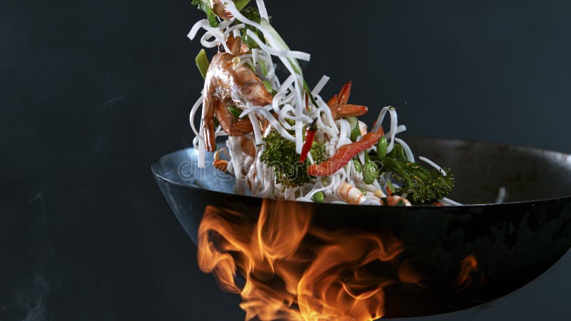 Freeze Motion of Wok Pan and Flying Ingredients in the Air. Stock Image ...