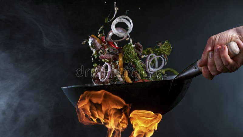 Freeze Motion of Wok Pan and Flying Ingredients in the Air. Stock Image ...