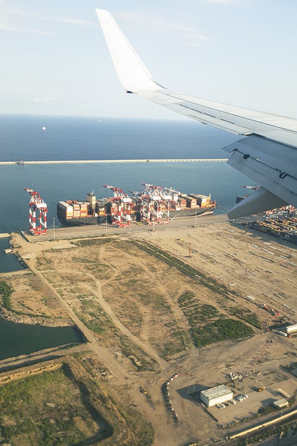 Freight Cargo Ship Loading on a Harbour Seen from an Airplane Wing ...
