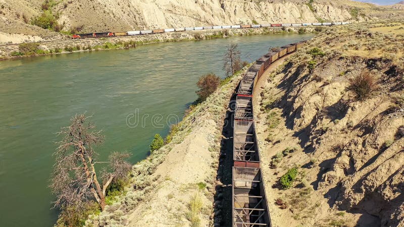 Freight Railway Trains Pass on Both Sides of River. Muddy River Stock ...