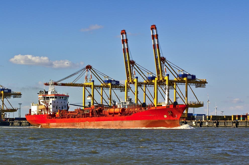 Freight Ship in Front of Port Facilities and Cranes Stock Photo - Image ...