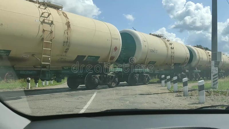 A Freight Train with Liquid Tanks and Freight Cars Passes a Railway ...