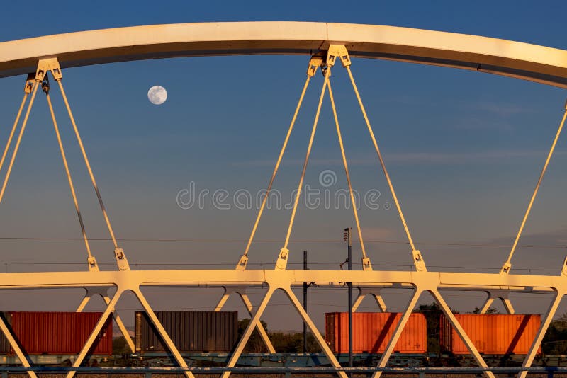 Freight Train Passing a Bridge at Sunset with the Full Moon Stock Photo ...