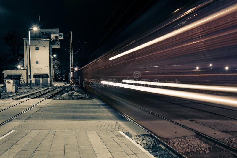 A Freight Train Passing Through The Train Station At Night Stock Image ...