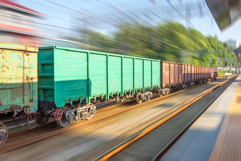 Freight Train Rushes at High Speed Past the Passenger Station Stock ...