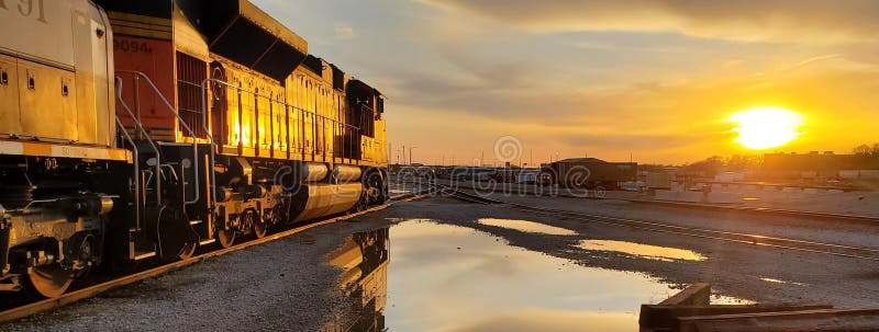 Freight Train at Sunset with Reflection in Puddle. Stock Image - Image ...