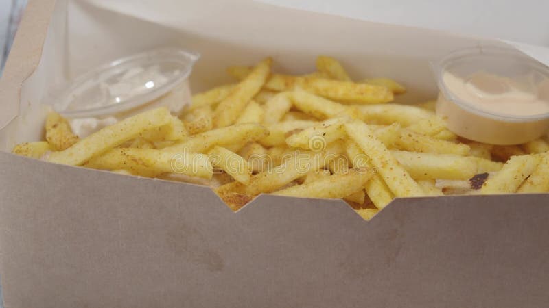 French Fries in a Paper Packet on Table Stock Footage - Video of ...