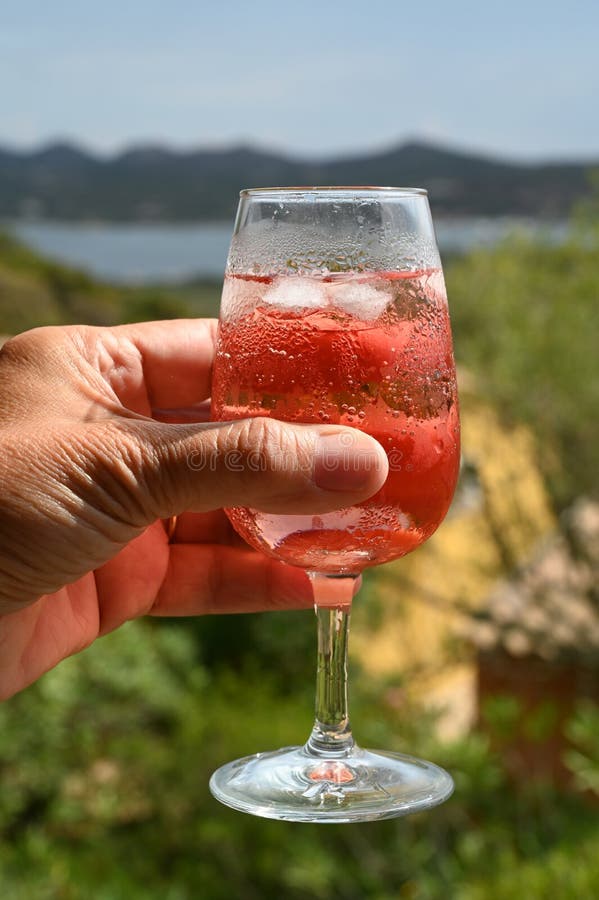 A Glass of Wine with Ice Cubes in Hand Close-up Stock Photo - Image of ...