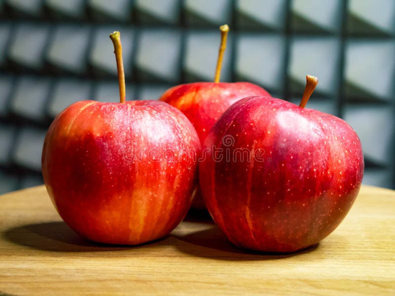 Fresh Apples on Display. Three Red Apples with Stems on a Wooden ...