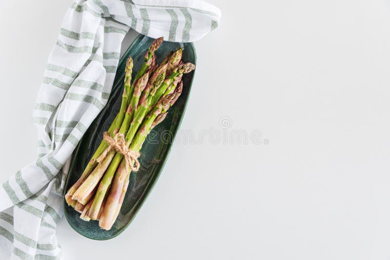 Fresh Asparagus Tied Bundle on Plate on White Table. Top View Stock ...