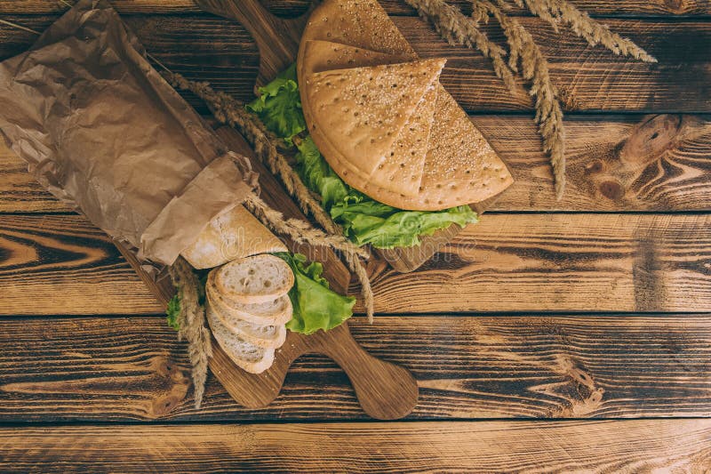 Fresh Bread with Lettuce in Paper Packaging, on a Fired Wooden Table ...