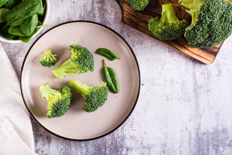Fresh Broccoli Divided into Inflorescences on a Plate on the Table ...